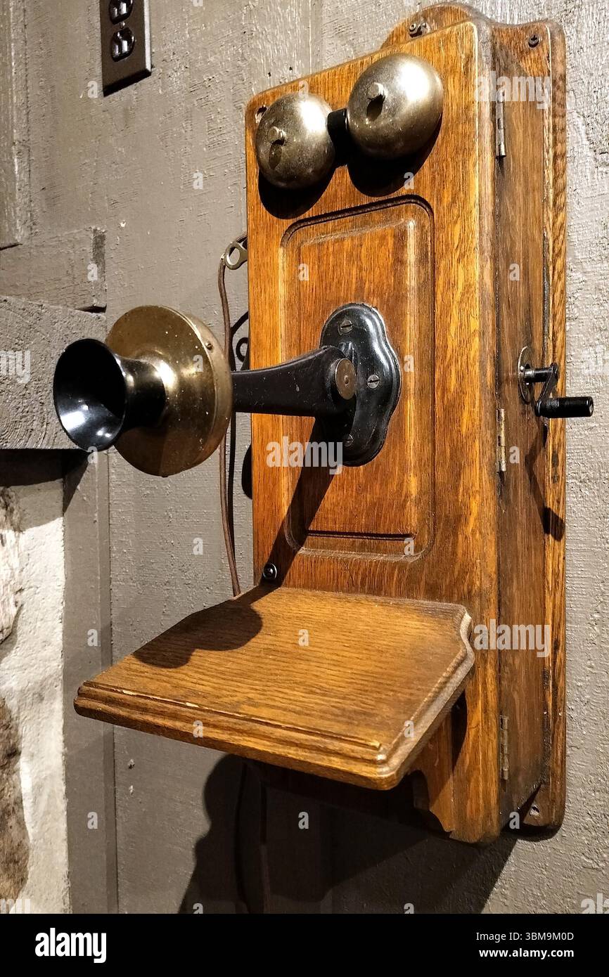 Wall-mounted vintage telephone with a wooden case and two brass bells ...
