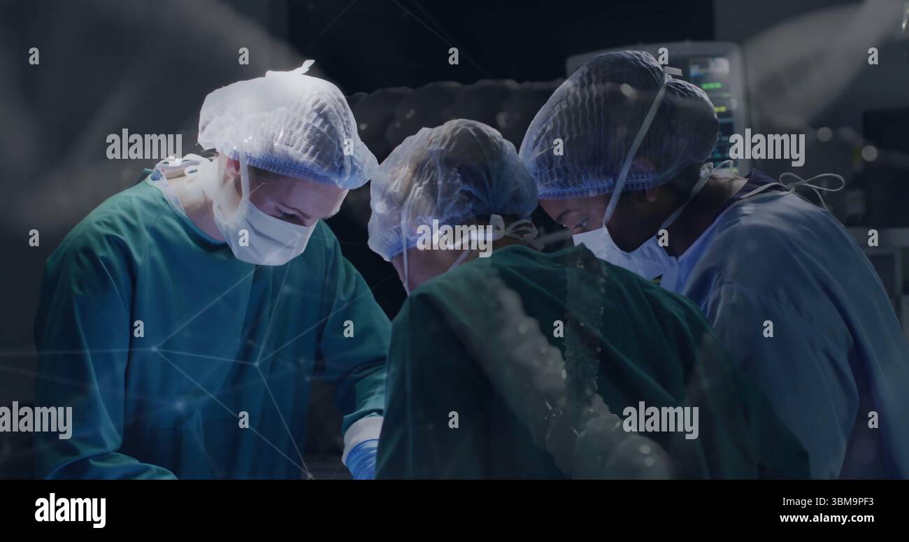 Operating surgeons wearing scrubs working under surgical light in ...