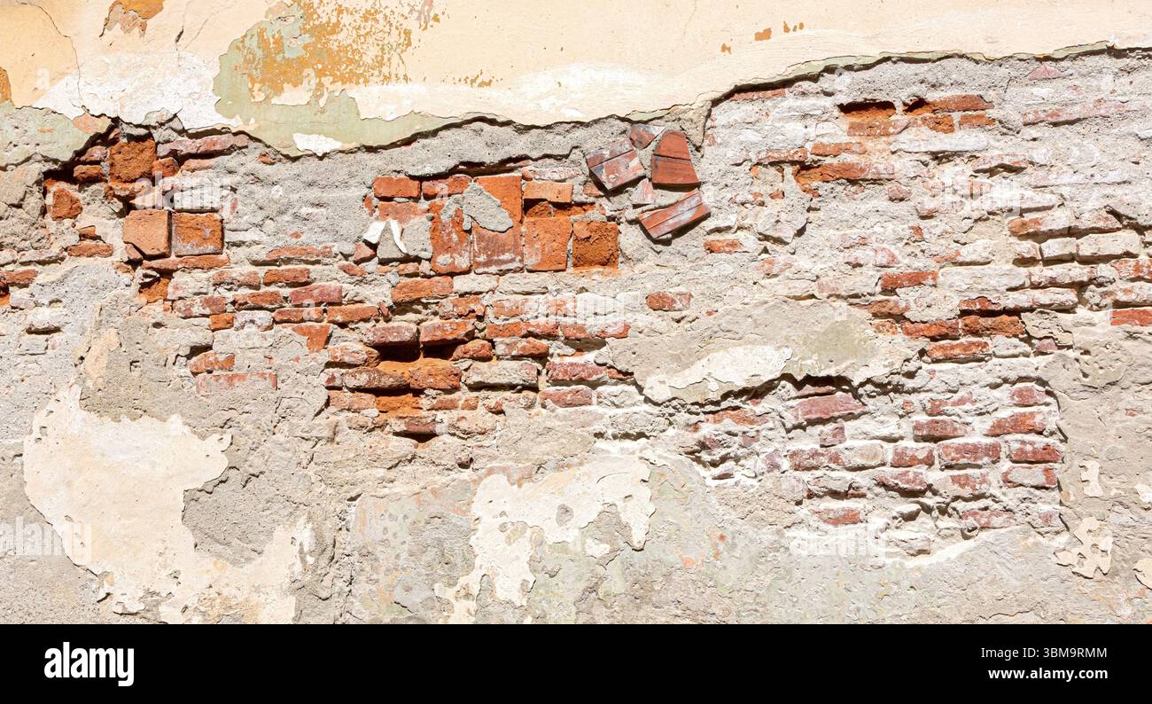 Weathered brick wall texture showing crumbling plaster and exposed red ...