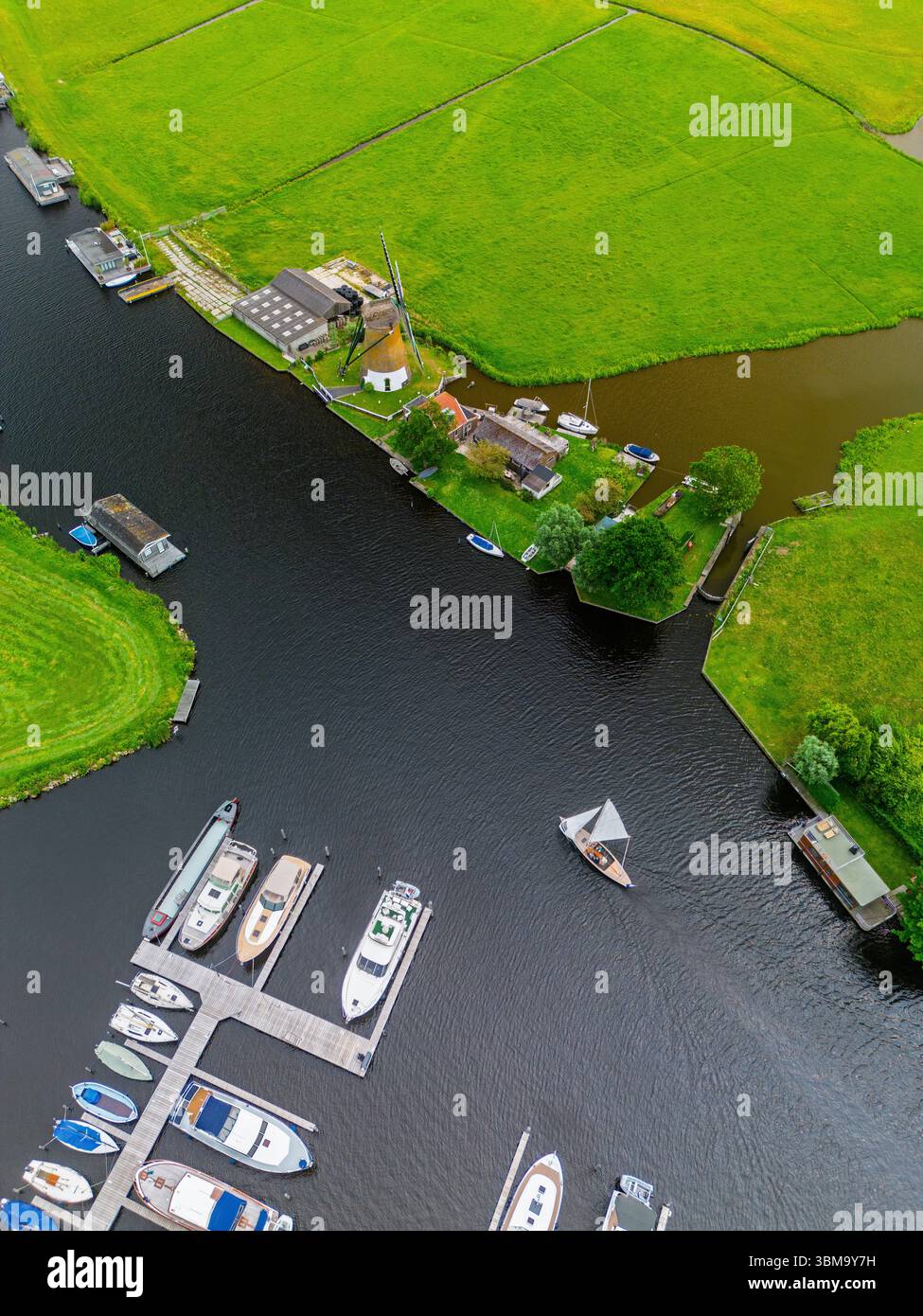 A top-down view of a marina with multiple boats docked along wooden ...