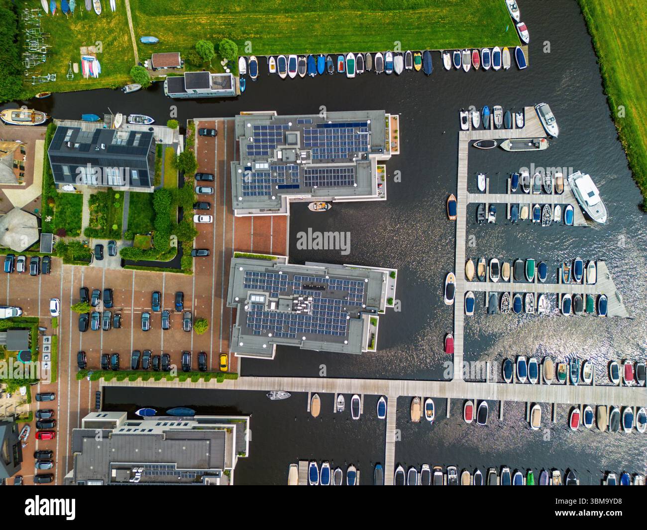 A top-down view of a marina with multiple boats docked along wooden ...
