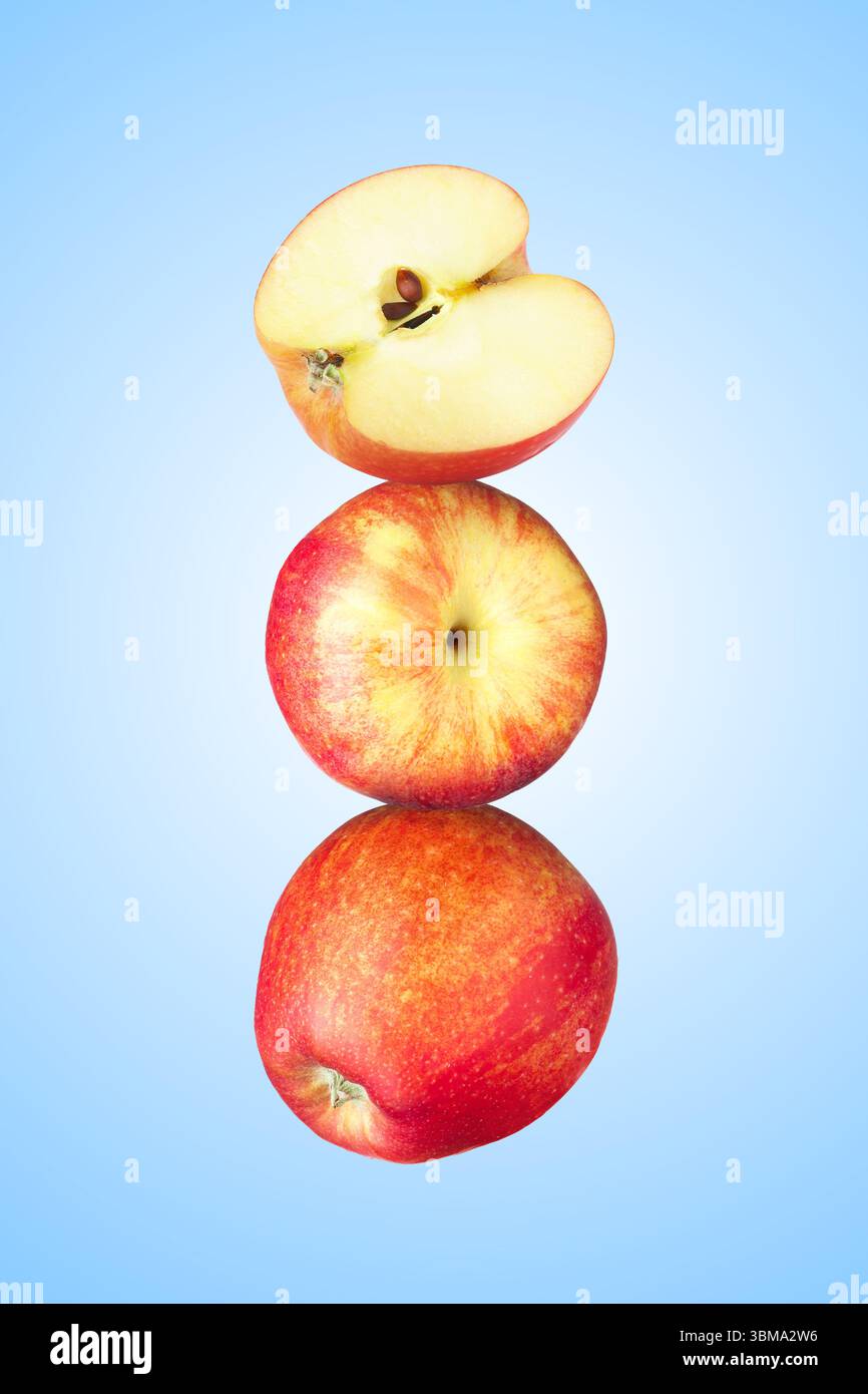 Apples stacked on top of each other against light blue background ...