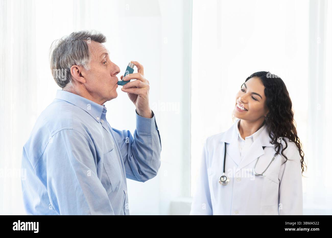 Physician examining mature man using blue asthma inhaler Stock Photo ...