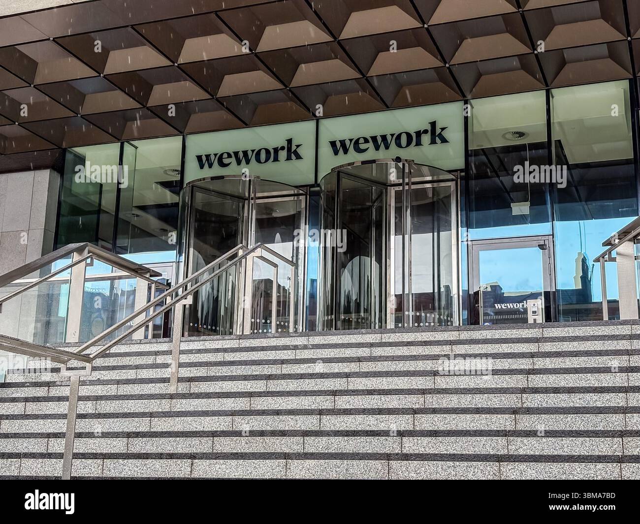 Wework office building entrance featuring revolving doors and exterior ...