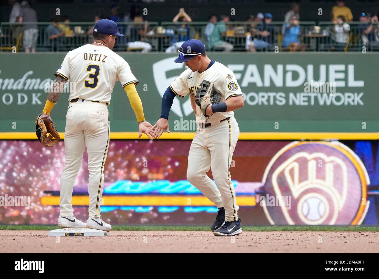Milwaukee Brewers shortstop Joey Ortiz (3) high-fives outfielder Isaac ...