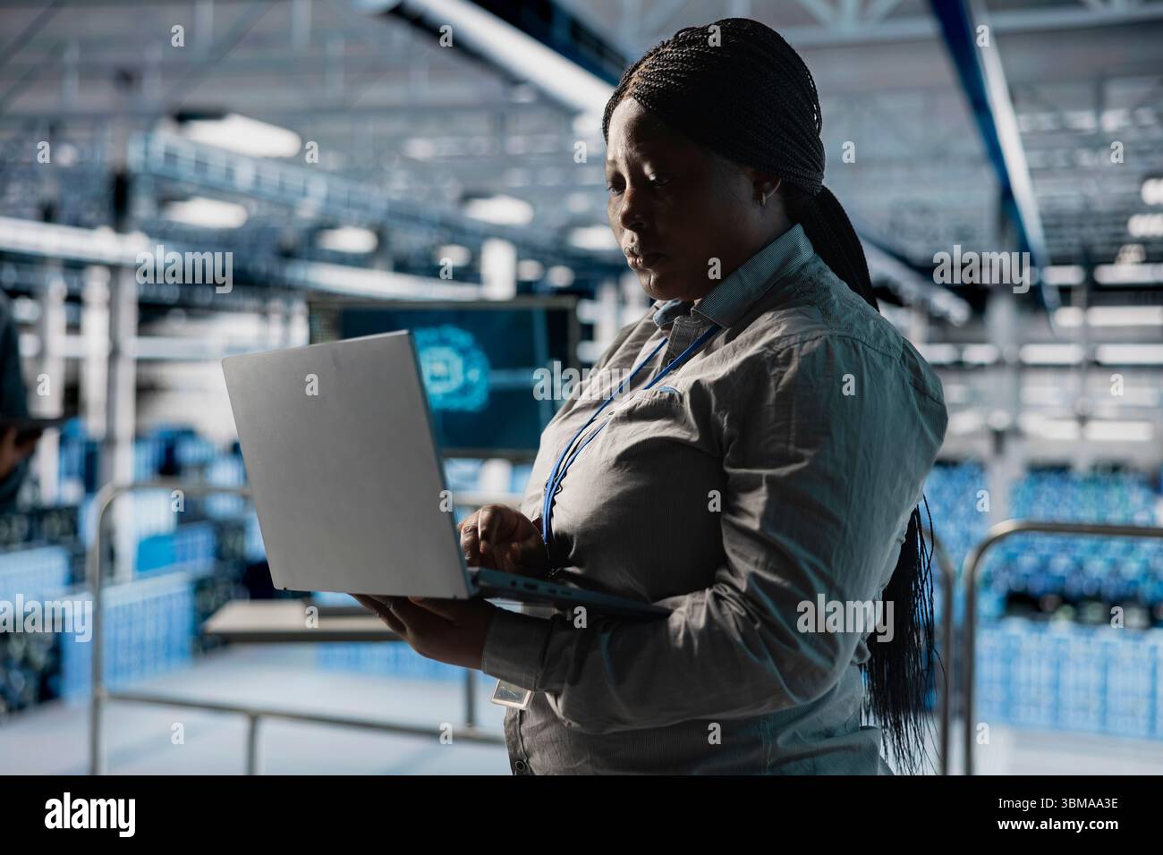 Data center female system administrator using laptop, configuring storage devices for minimal ...