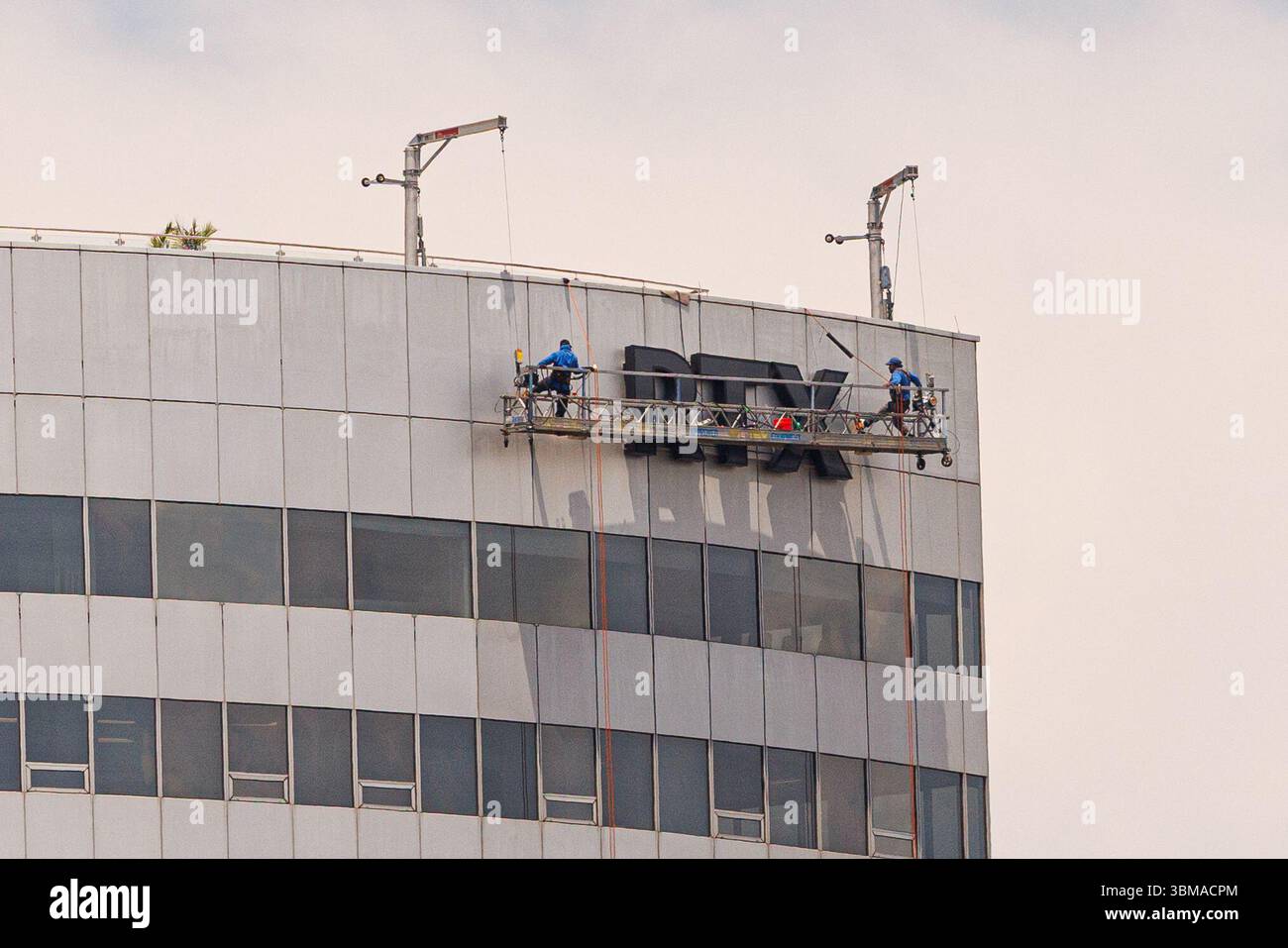 Workers along the top of the Raytheon Technologies Headquarters in ...