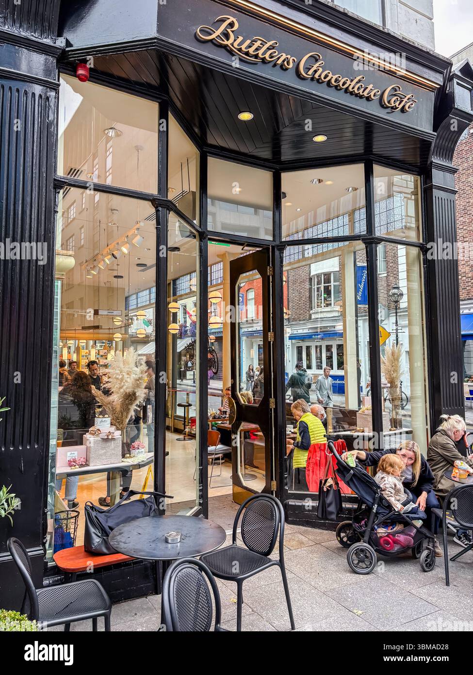 Butlers Chocolate Cafe storefront with outdoor seating and customers on ...