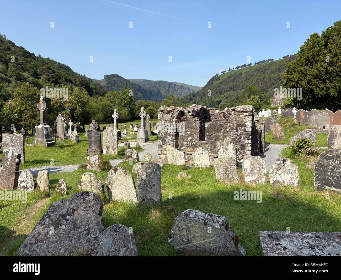 Cemetery with ancient gravestones, celtic crosses, and stone church ...