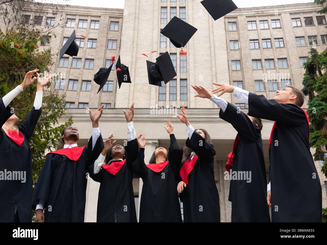 International group of students throwing graduation caps up Stock Photo ...