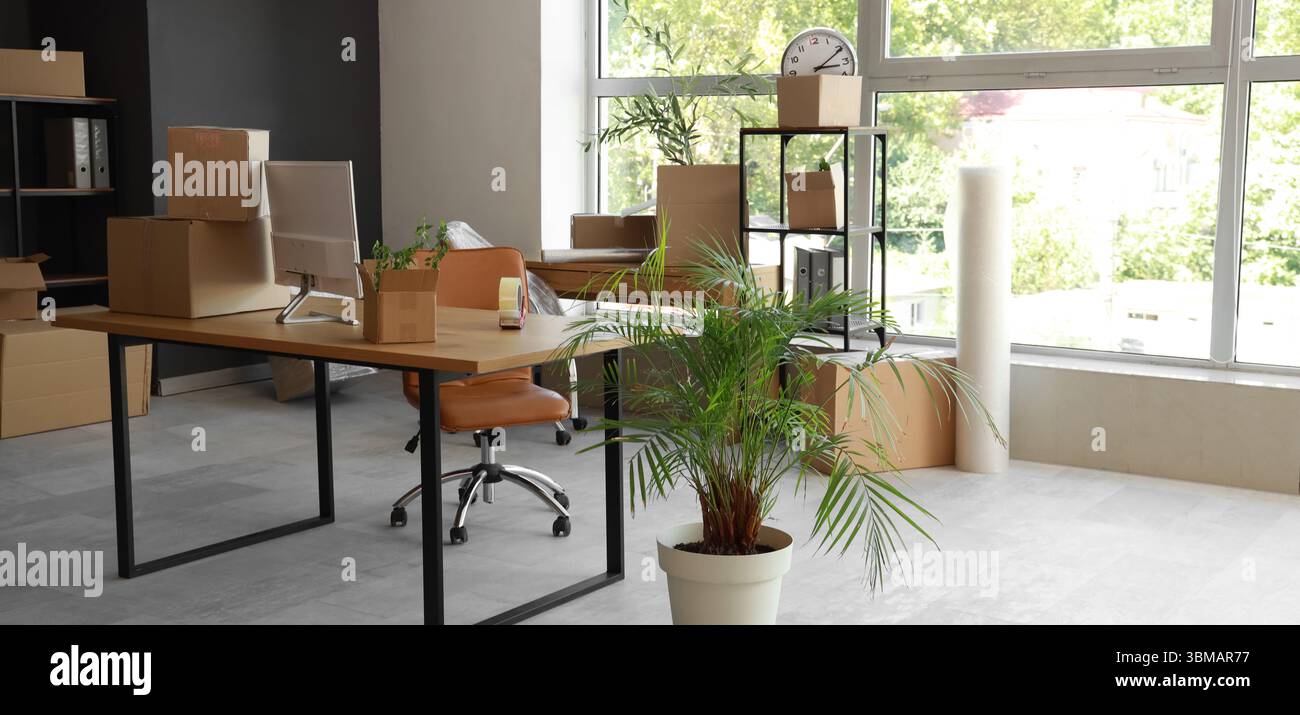 Modern workplace with computer monitor and cardboard boxes in office on ...