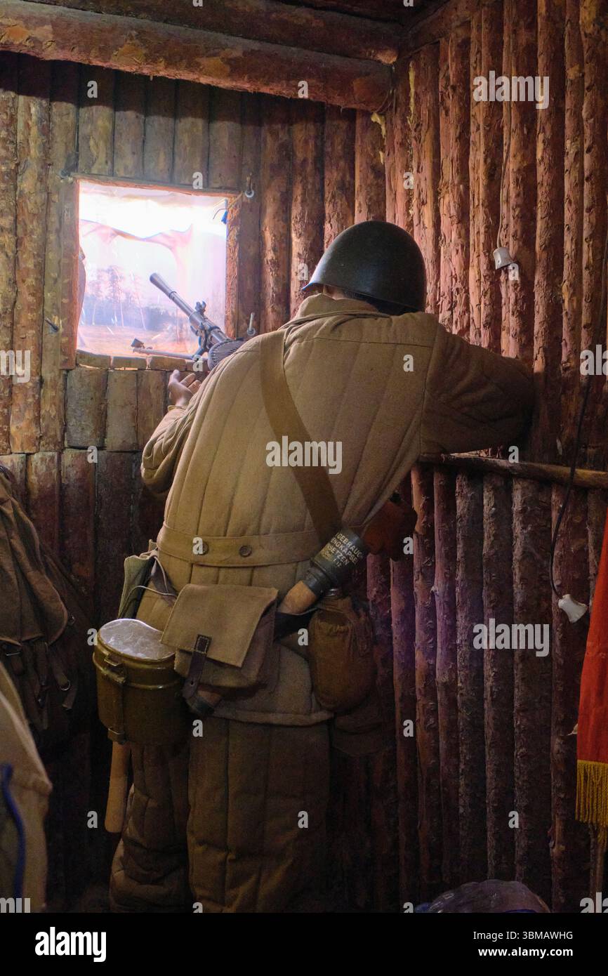 A soldier shooting a gun out of a hole in the log bunker. Part of a ...