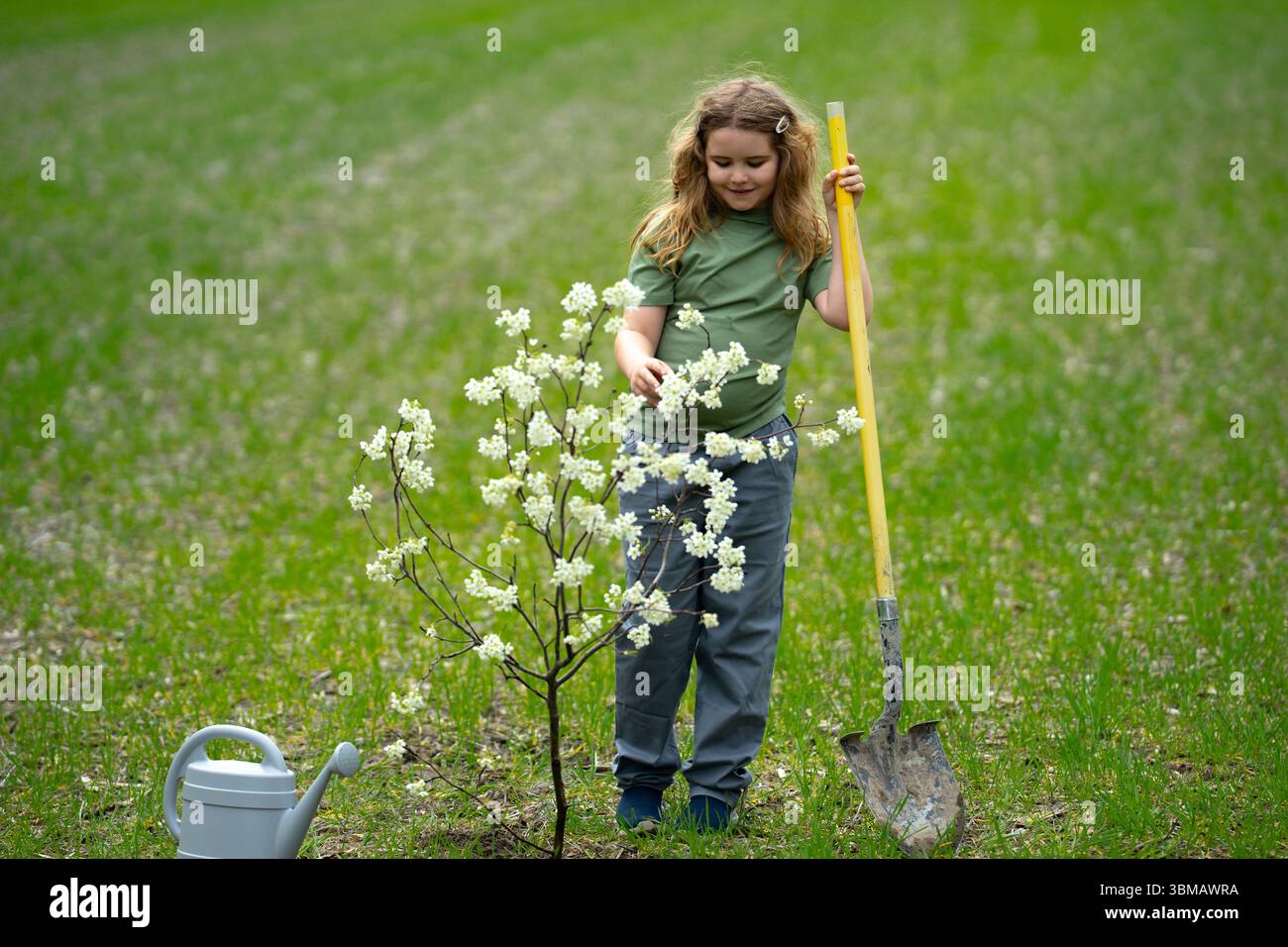Child planting tree outdoors. Spring activity of plant trees. Kid work ...