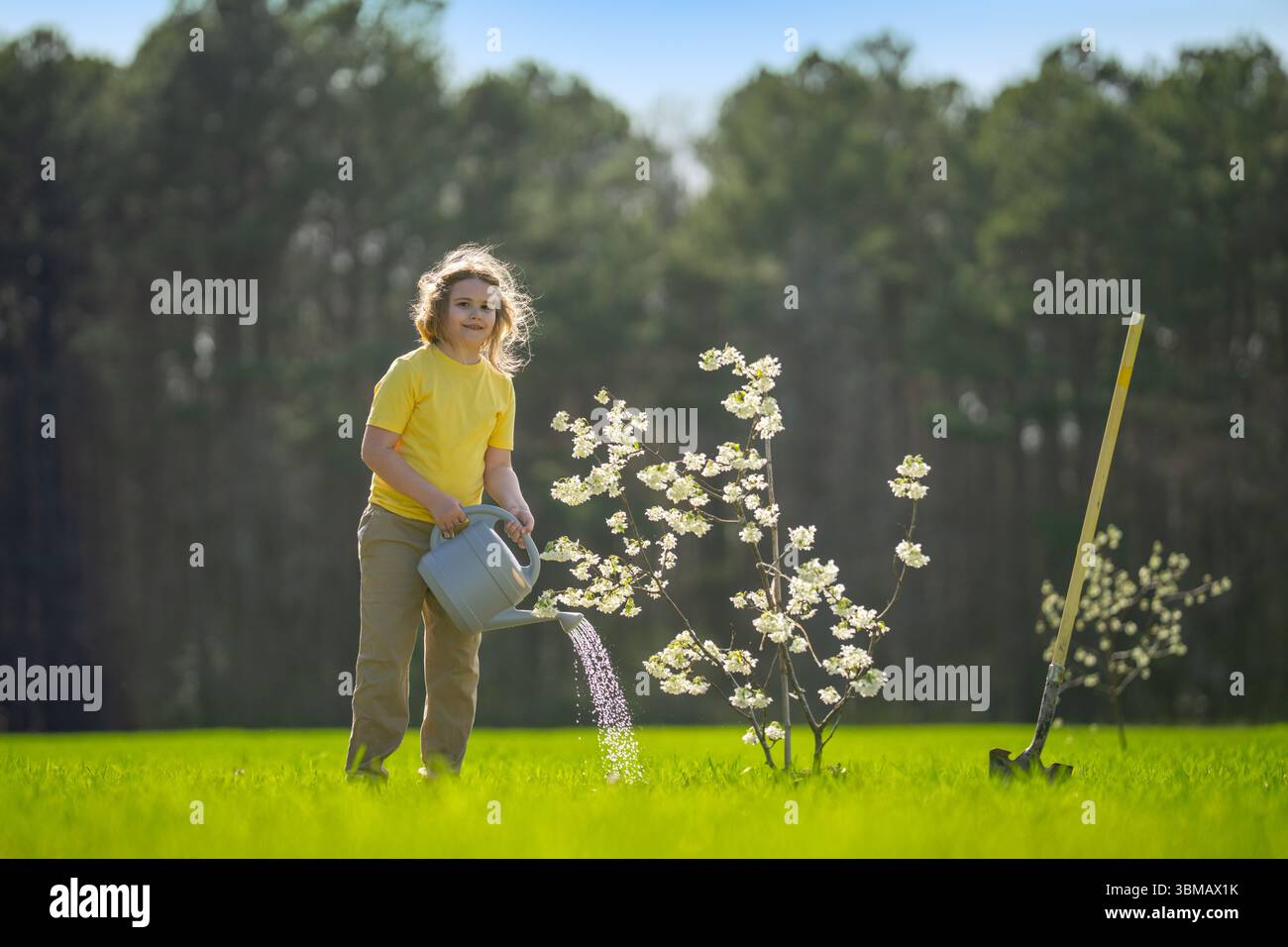 Kid plant a tree in garden. Kid digging soil with shovel and plant tree ...