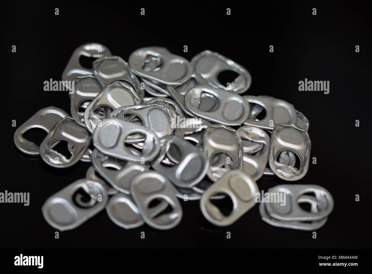 a pile of aluminum can tabs, also known as pull tabs or pop tabs. These ...