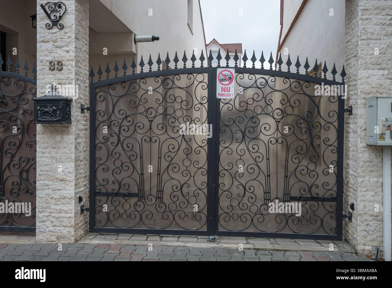 a large, ornate wrought iron gate with a translucent paneling, likely ...