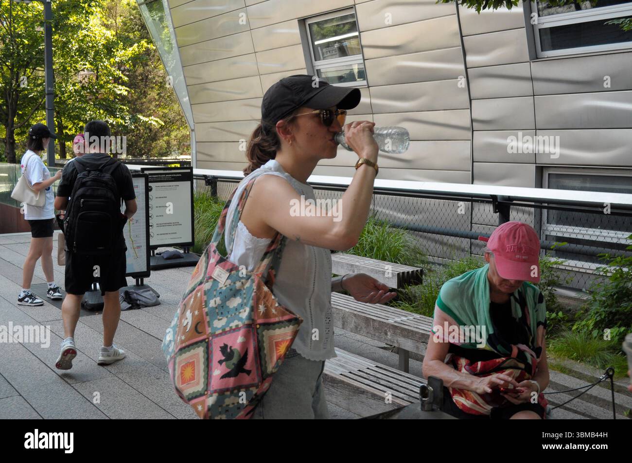 A person drinks water on the High Line during a summer heat wave. New ...