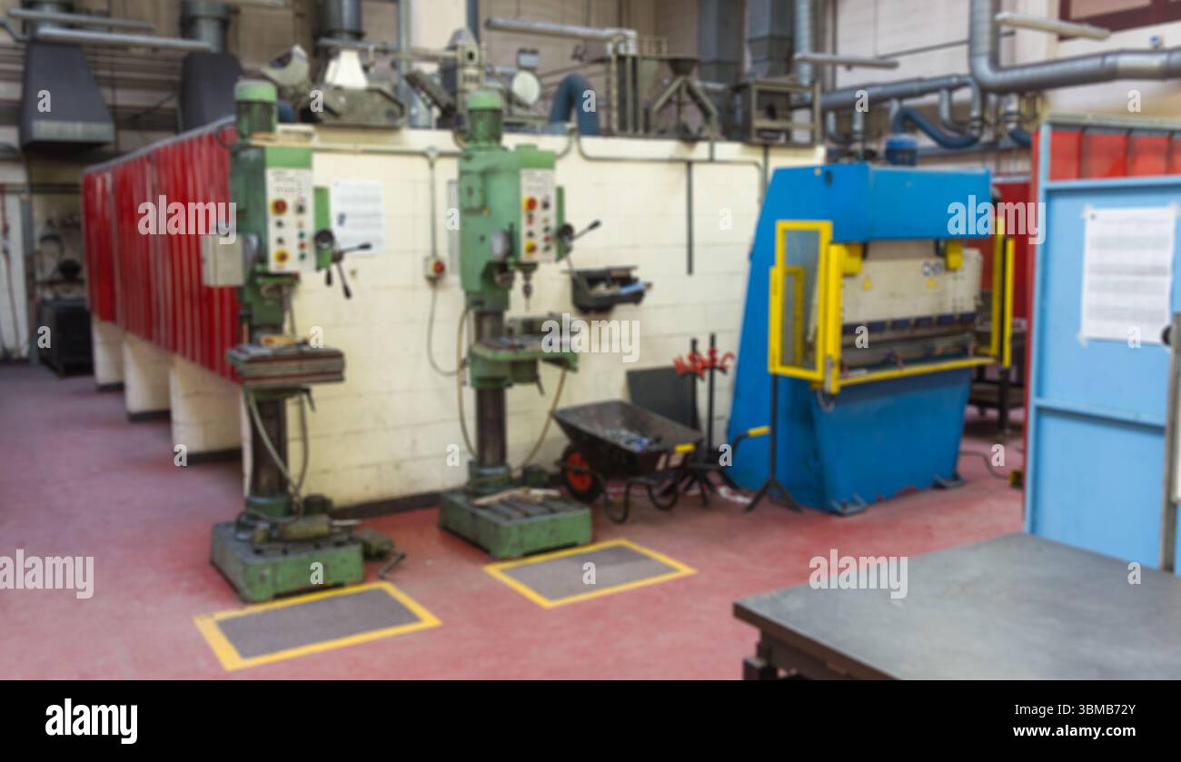Two green drill presses are standing with blue bending brake, black ...
