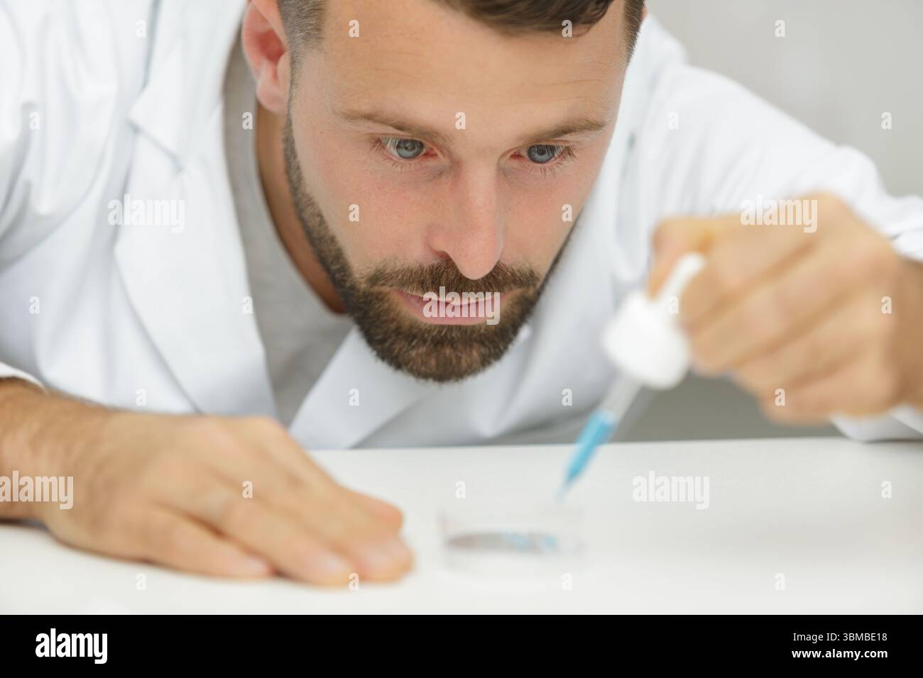 smart scientist man tests liquid substance in test tube Stock Photo - Alamy