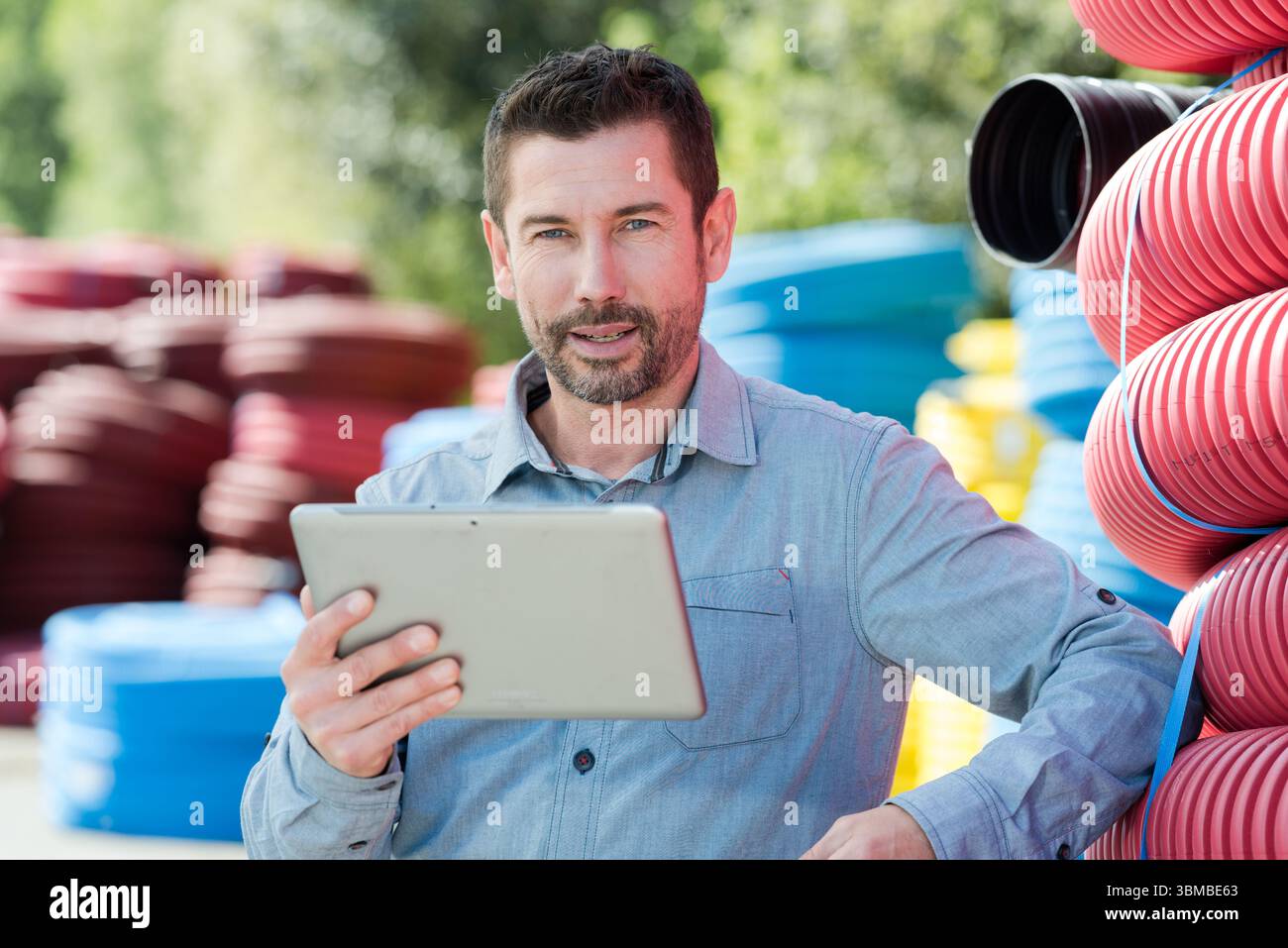 pipes and hose supplier holding tablet Stock Photo - Alamy