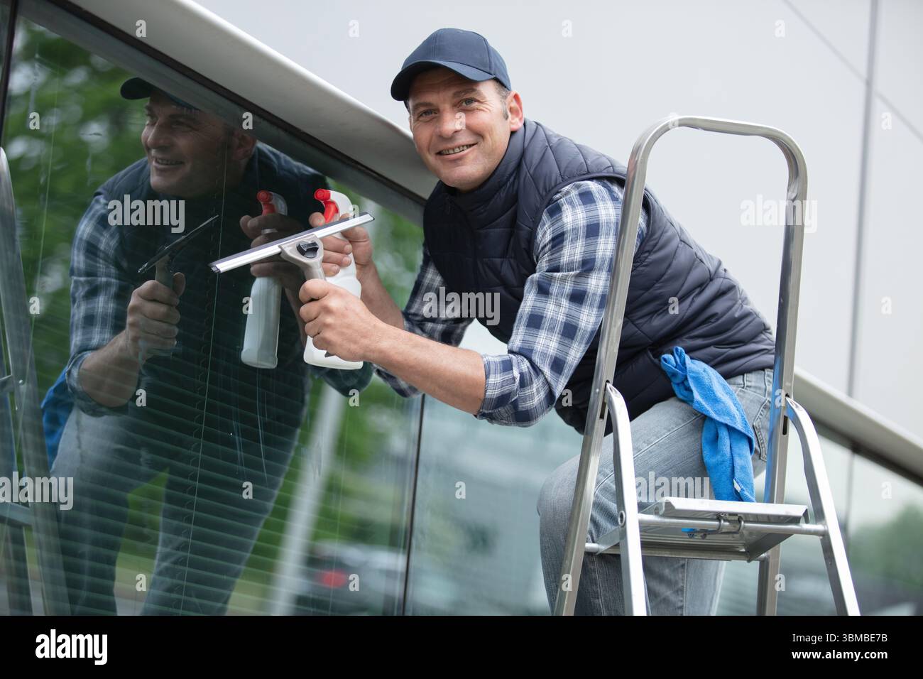 man on ladder caulking outside window Stock Photo - Alamy