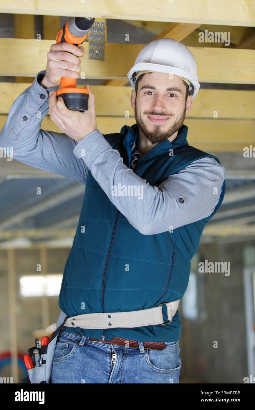 a professional man is drilling into a house ceiling Stock Photo - Alamy