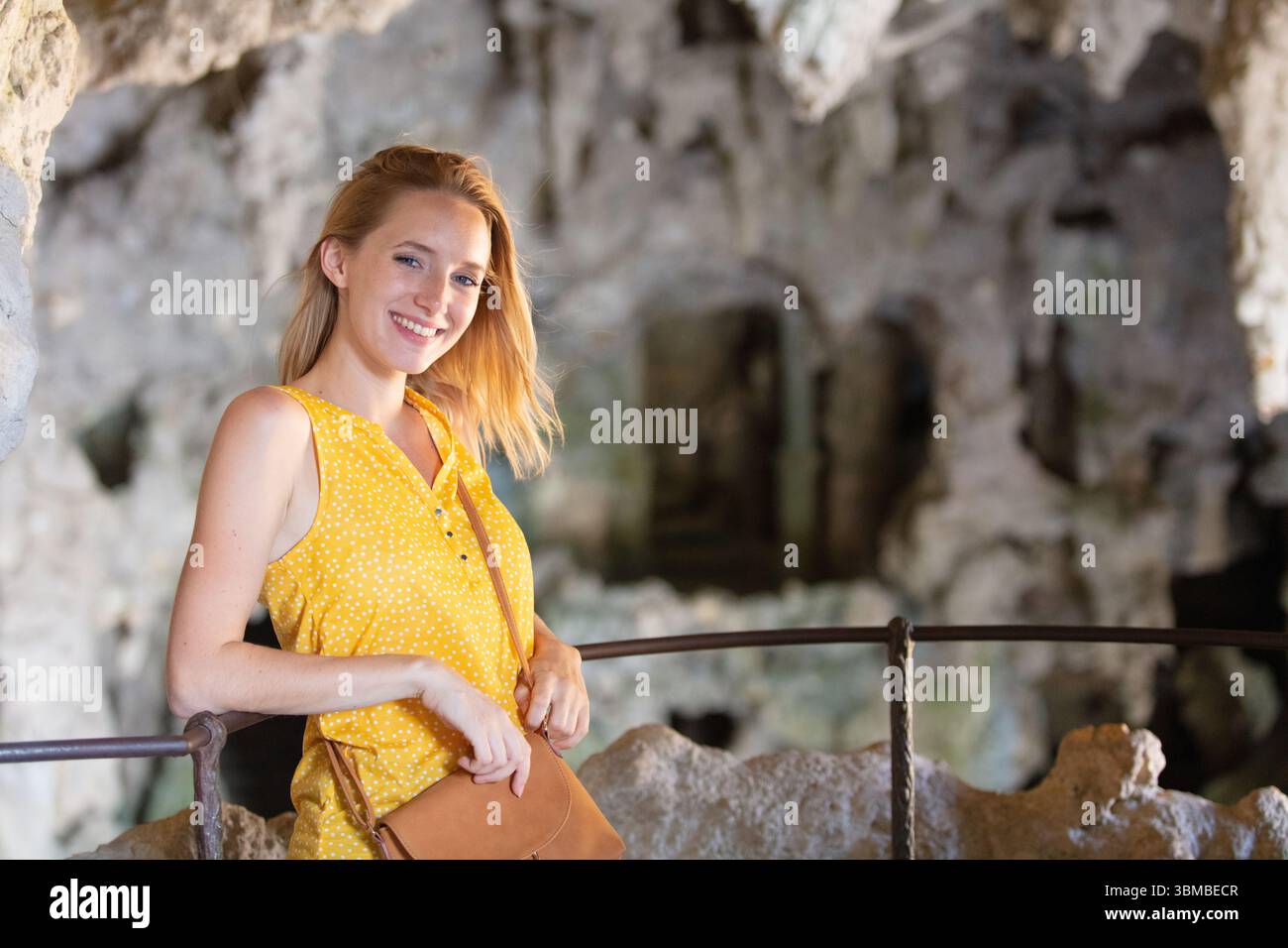 cute female wearing yellow dress in a cave Stock Photo - Alamy