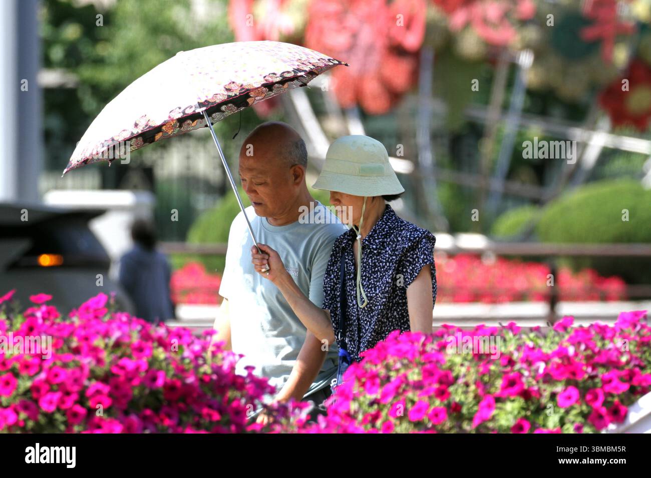 People wearing sun protective clothing on a street in Shenyang City ...