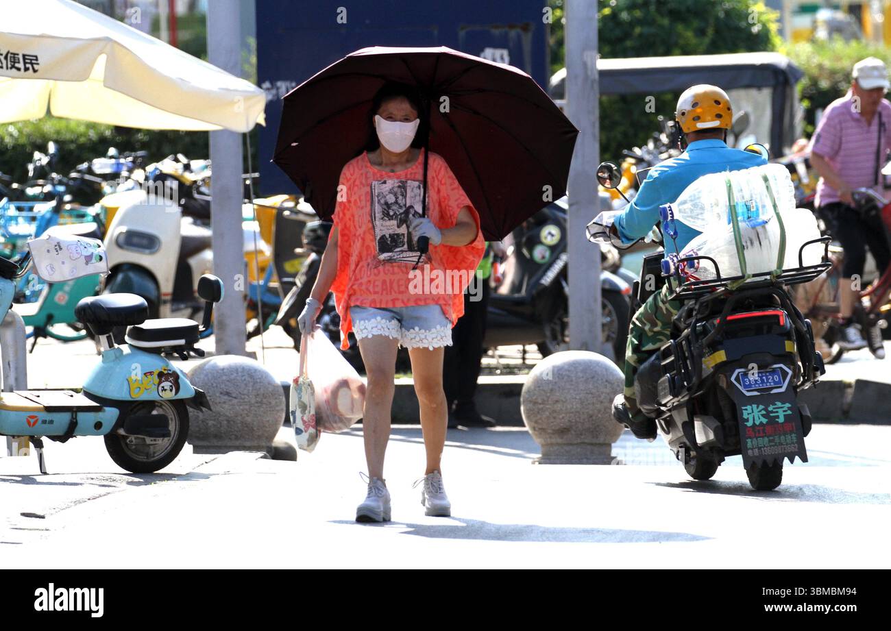 People wearing sun protective clothing on a street in Shenyang City, northeast China's Liaoning ...