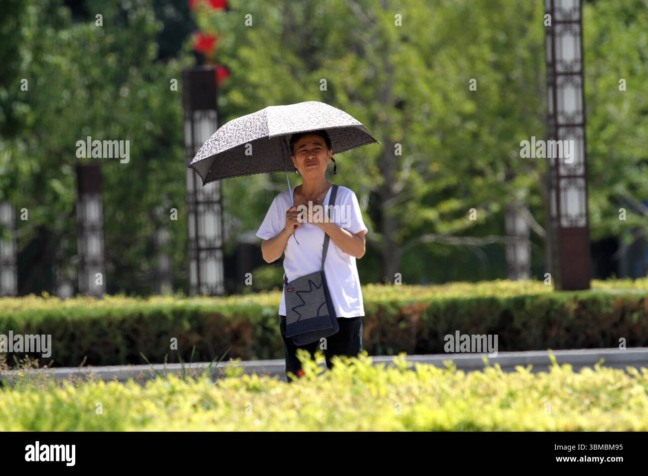 People wearing sun protective clothing on a street in Shenyang City ...