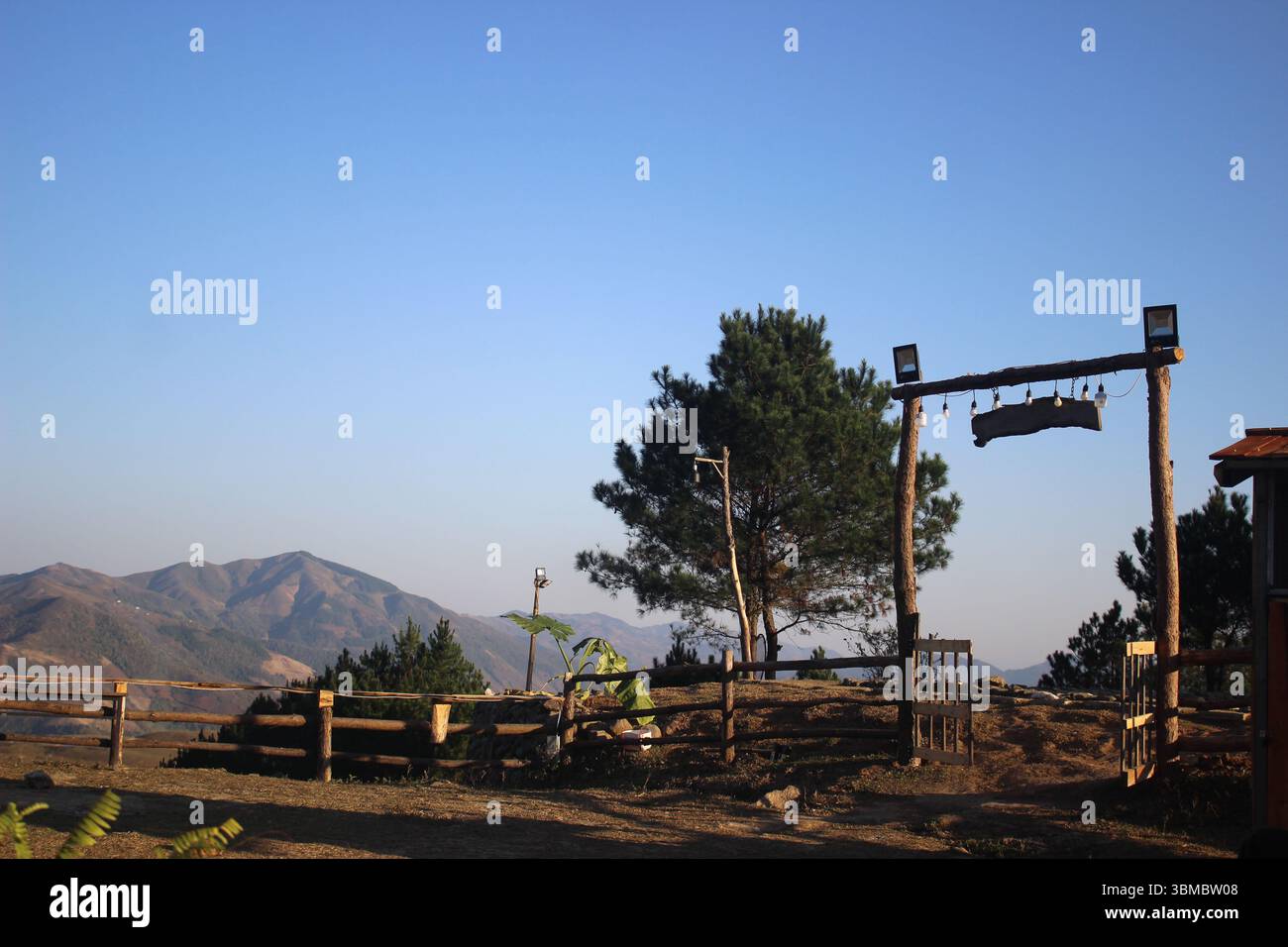 A scenic view of a rustic wooden gate with hanging lights, set against ...