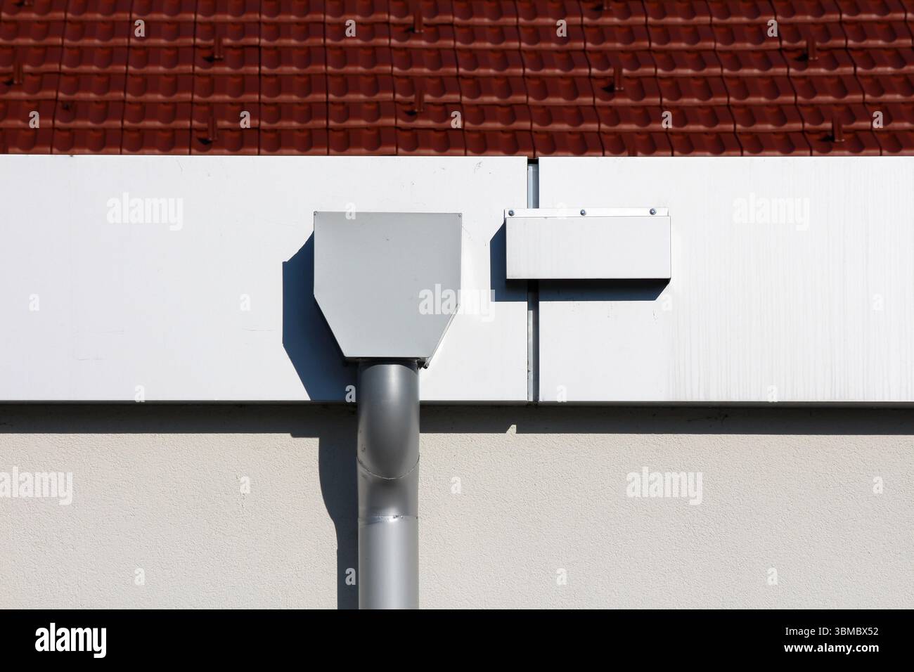 Close-up of a gray metal downspout and box gutter system attached to a ...