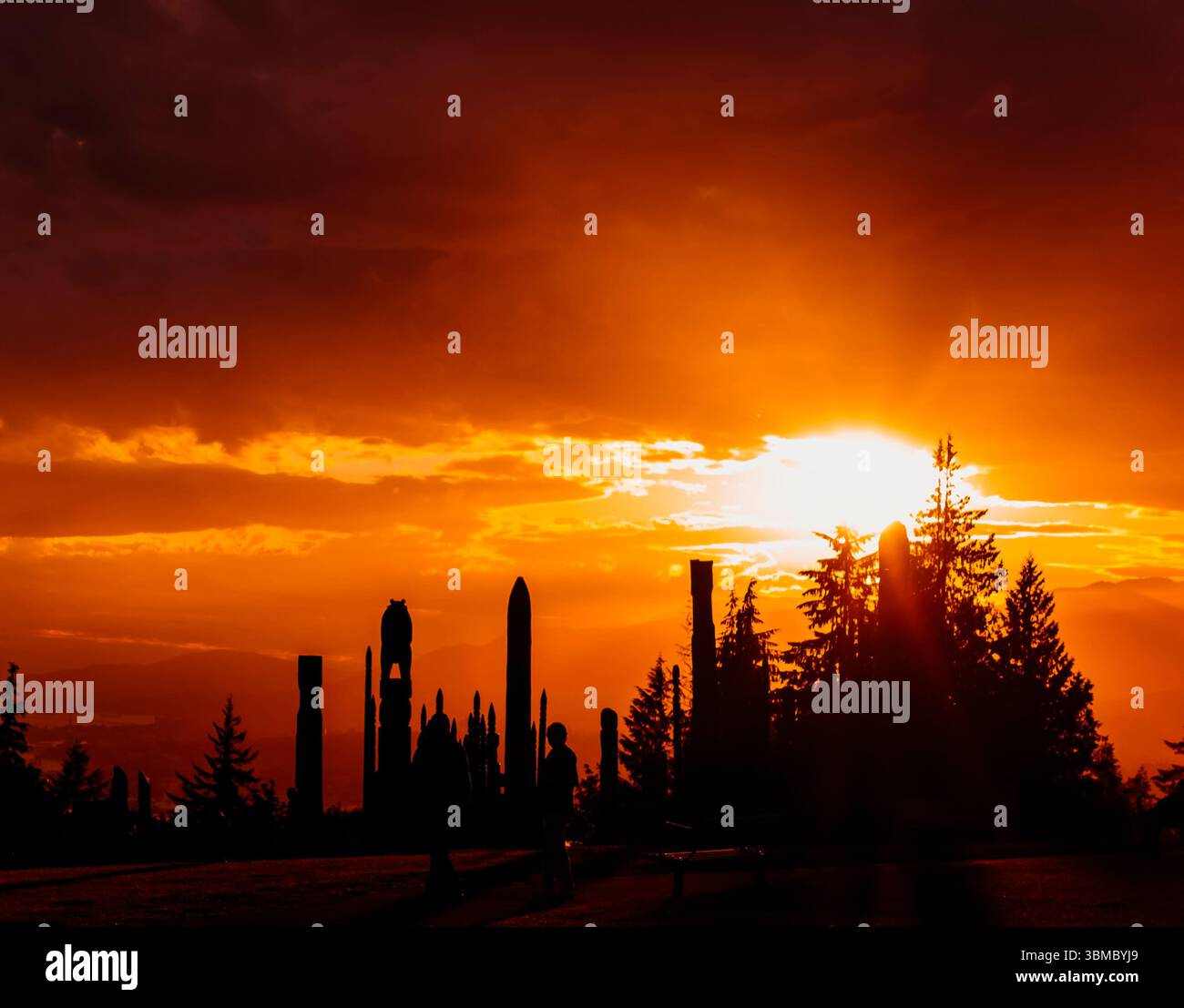 A breathtaking sunset casts vibrant orange hues over a landscape ...