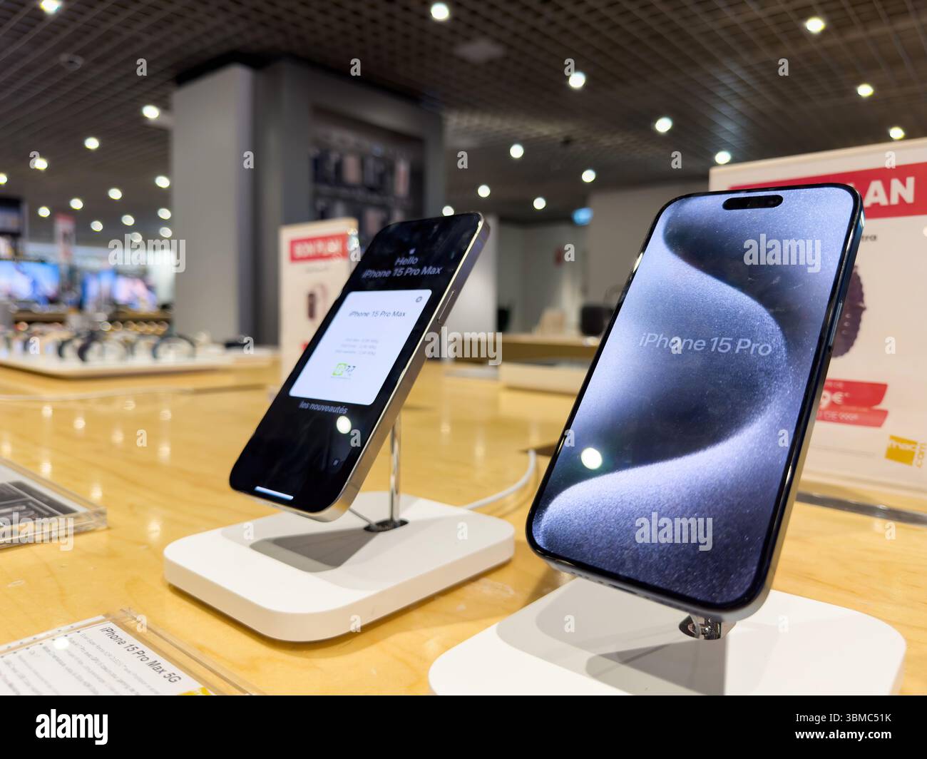 Paris, France - Mar 10, 2023: Two iPhone 15 Pro smartphones are displayed on stands in a bright ...