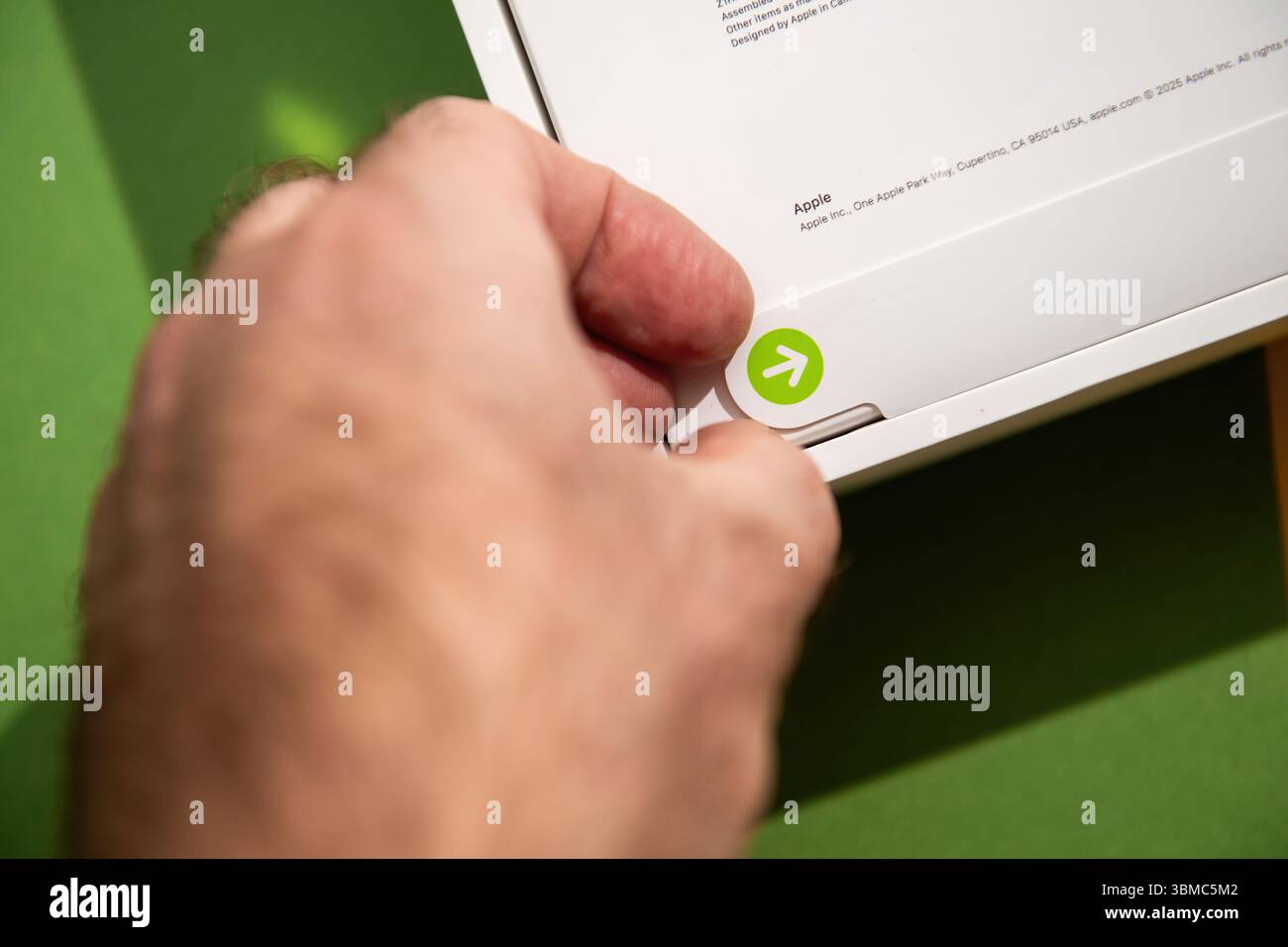 Paris, France - Mar 13, 2025: A hand pulls the green arrow tab to open ...