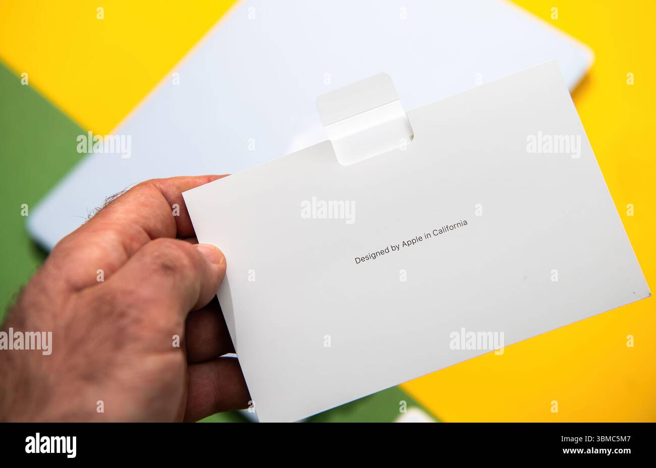 Paris, France - Mar 13, 2025: Hand holding Designed by Apple in ...