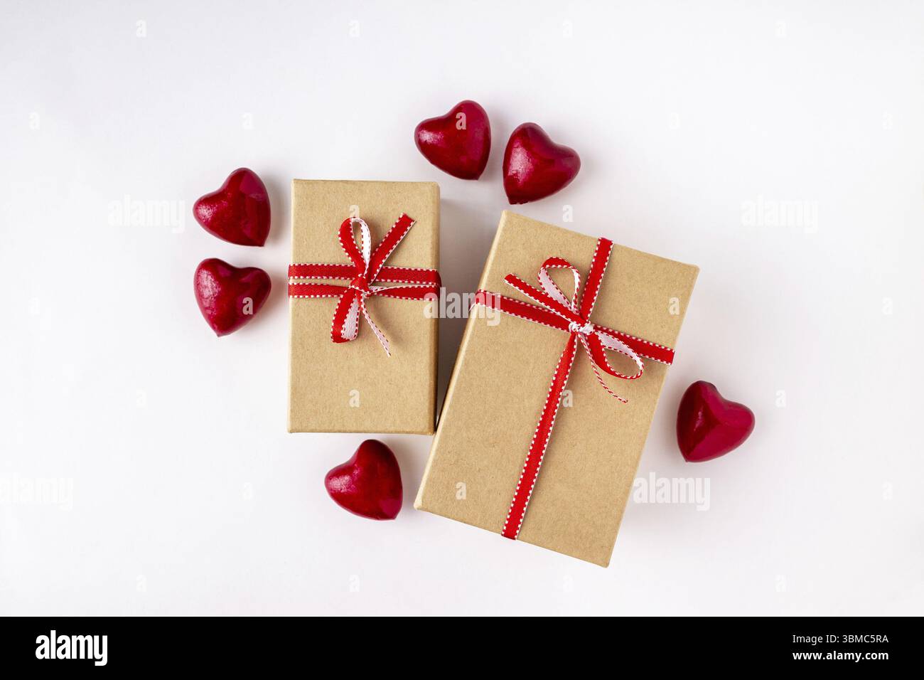 Cardboard boxes with red ribbons and red hearts on a white background ...