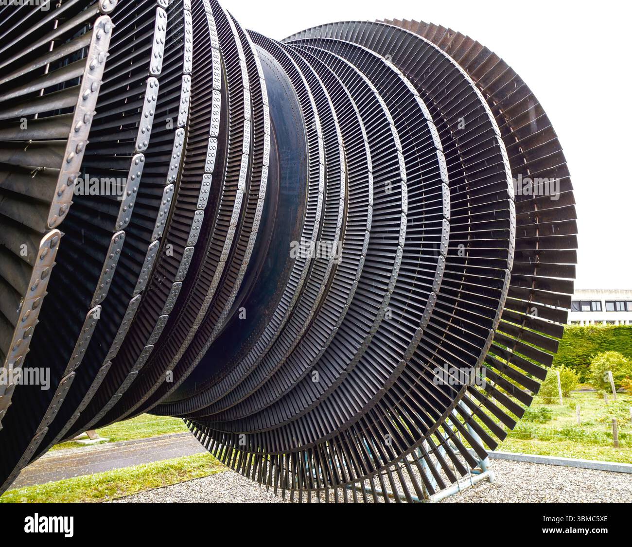 Close-up view of a large metallic turbine rotor with numerous evenly ...