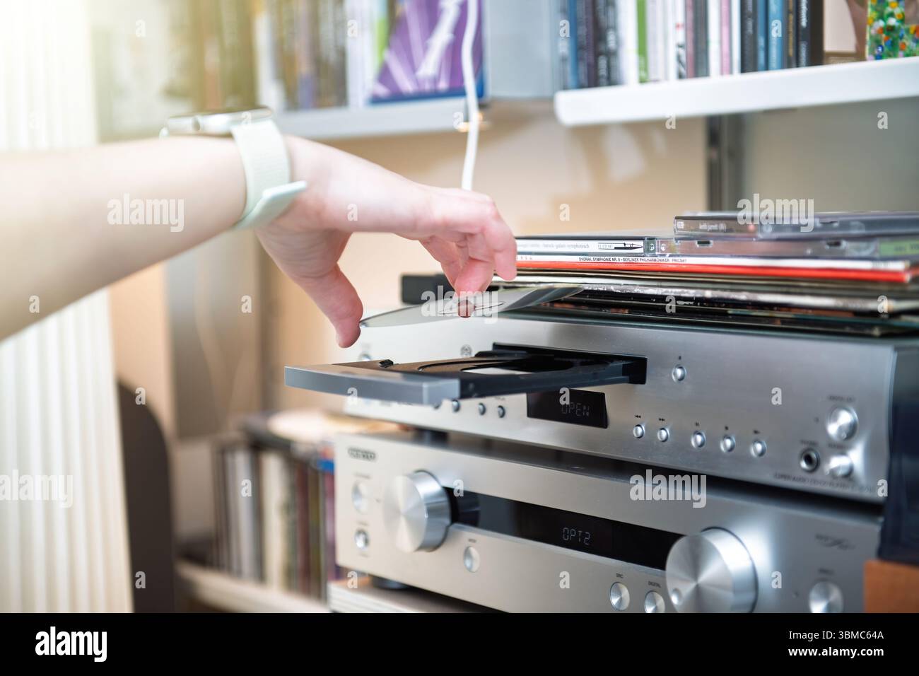 Paris, France - Apr 22, 2025: Person inserting a Super Audio CD into a ...