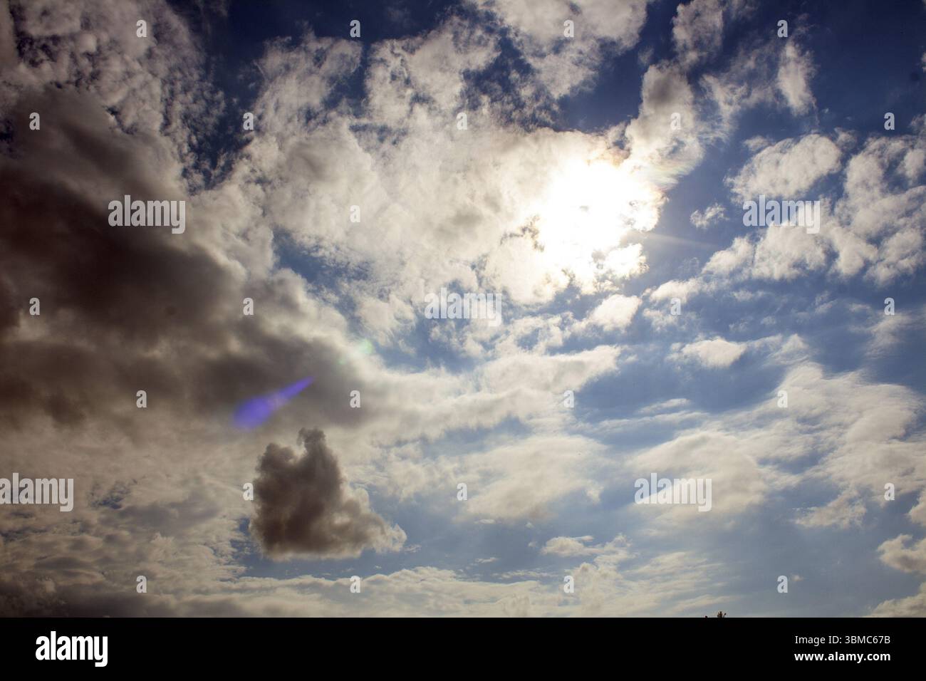 Blue sky, a ray of sun breaks through the clouds Stock Photo - Alamy