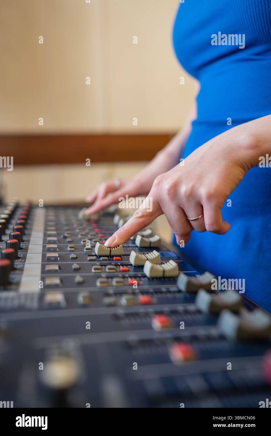 Hands Adjusting Sound Levels on Mixing Console Stock Photo - Alamy