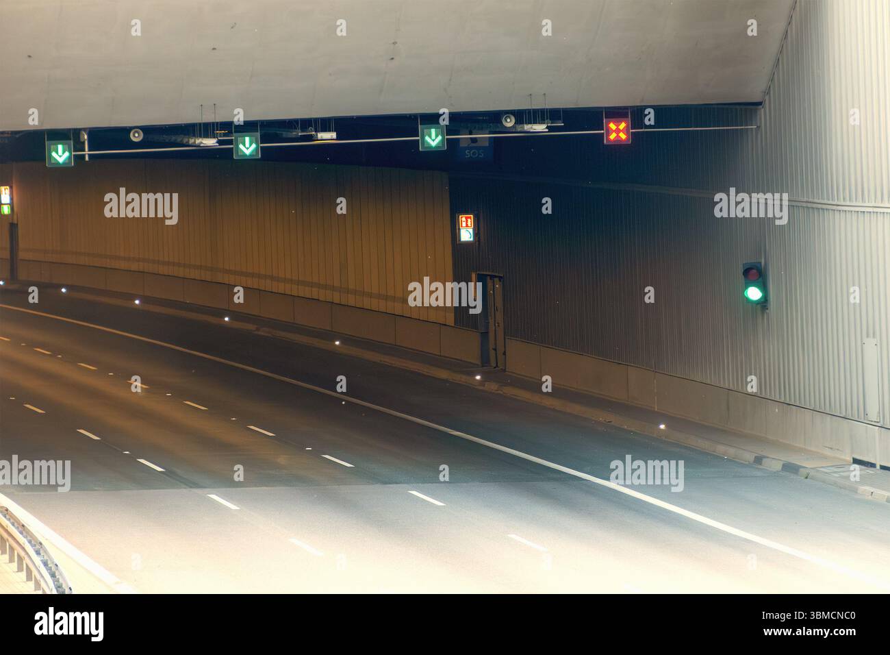 Illuminated urban tunnel with traffic lights and motion arrow ...