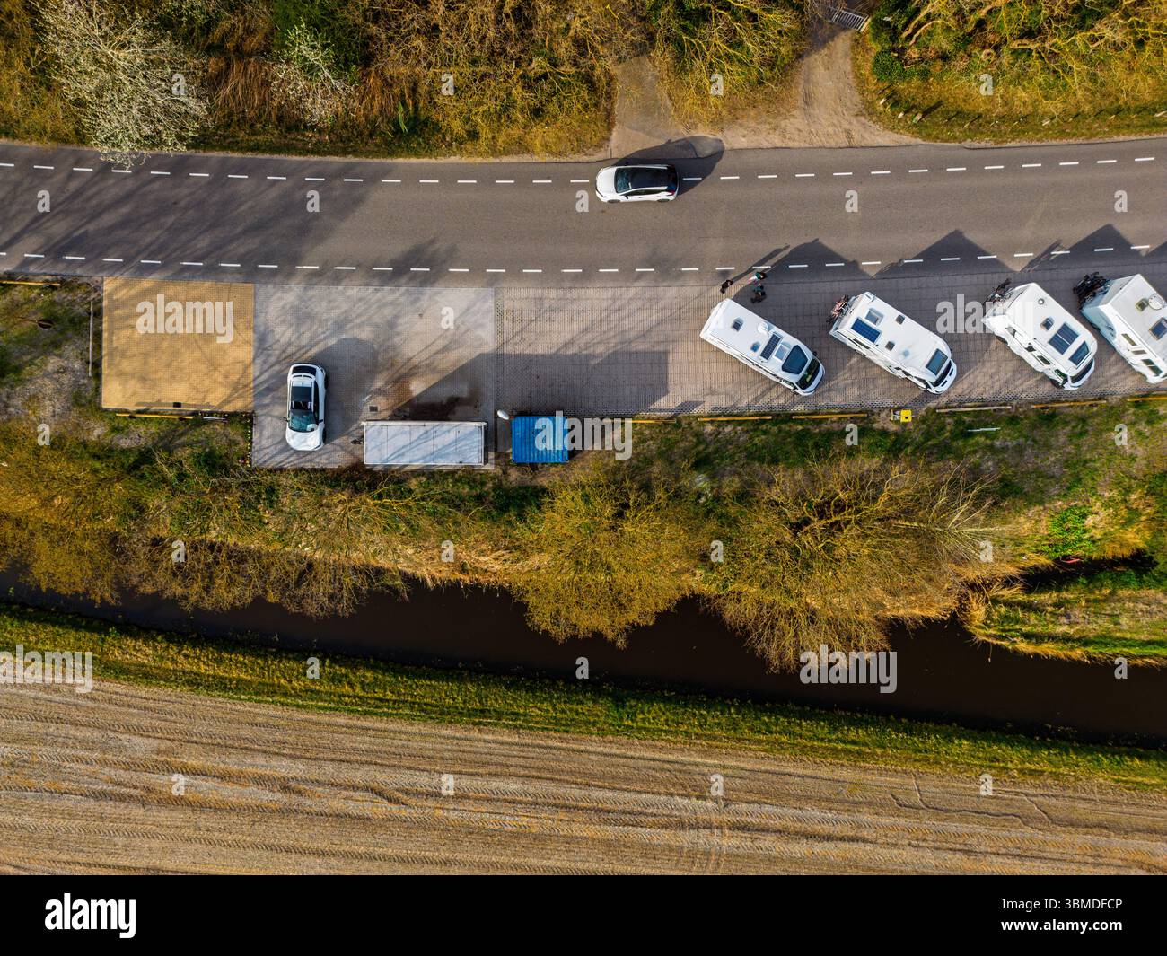 Aerial view of a forested landscape with camper vans parked along a ...