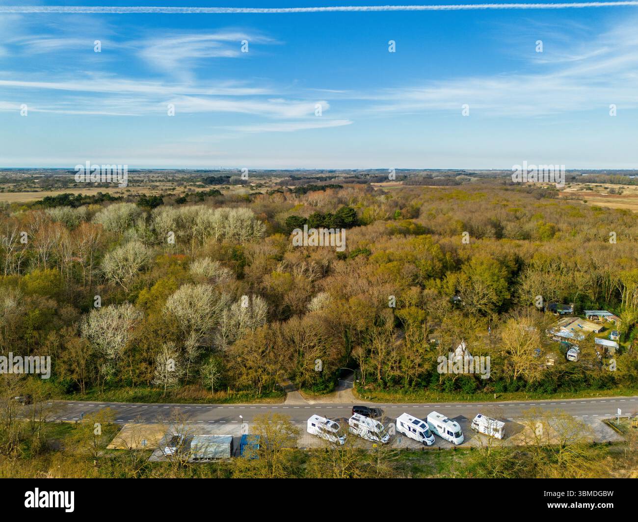 Aerial view of a forested landscape with camper vans parked along a ...
