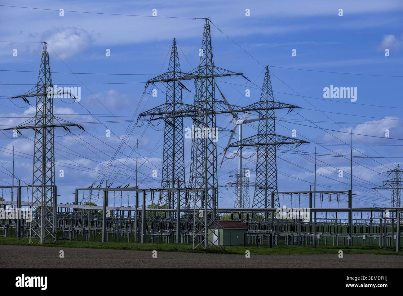Power pylons with high-voltage lines and wind turbine at the Avacon ...