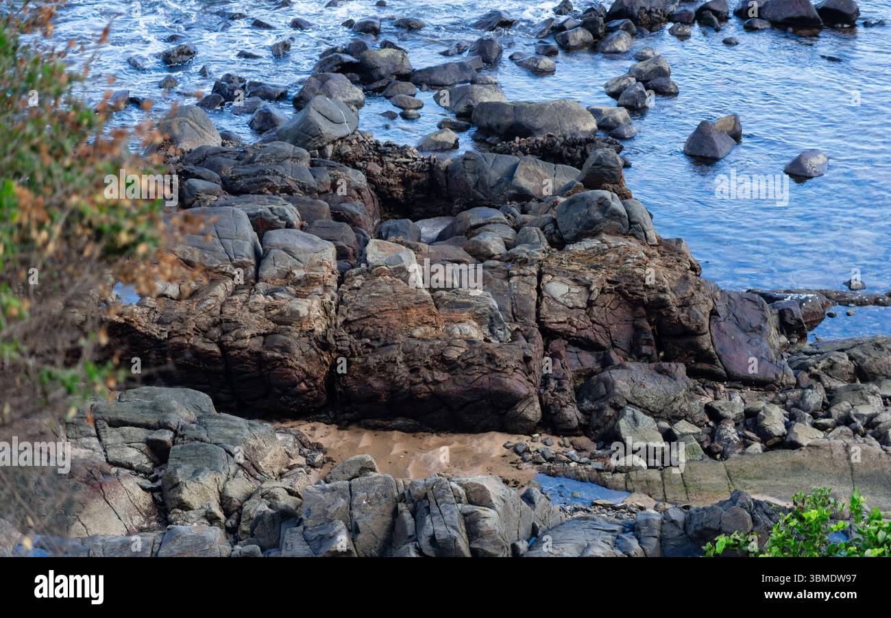 View of beach waves breaking on dark rocks during low tide. Paradise ...