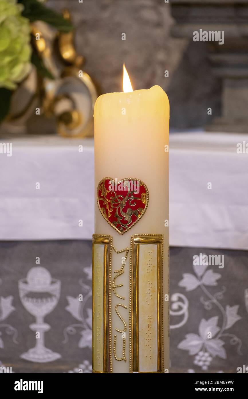 Candle with red heart and inscription Jesus in the collegiate parish ...