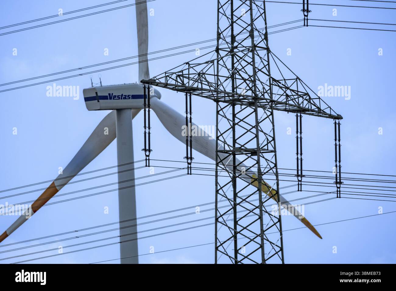 Power pylon with high-voltage lines and Vestas wind turbine at the ...