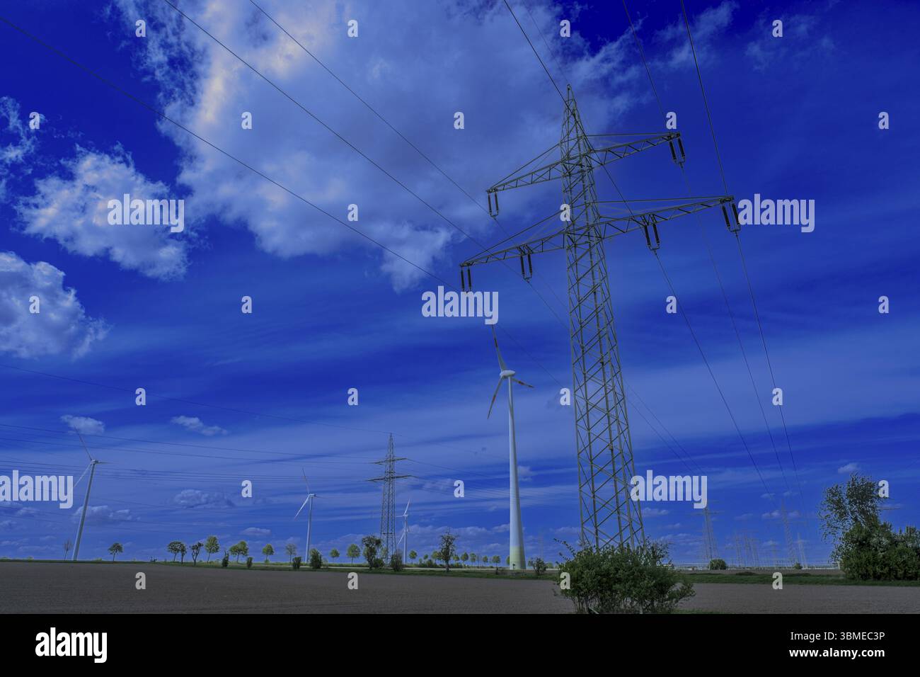 Power pylons with high-voltage lines and wind turbines on the K63 road ...