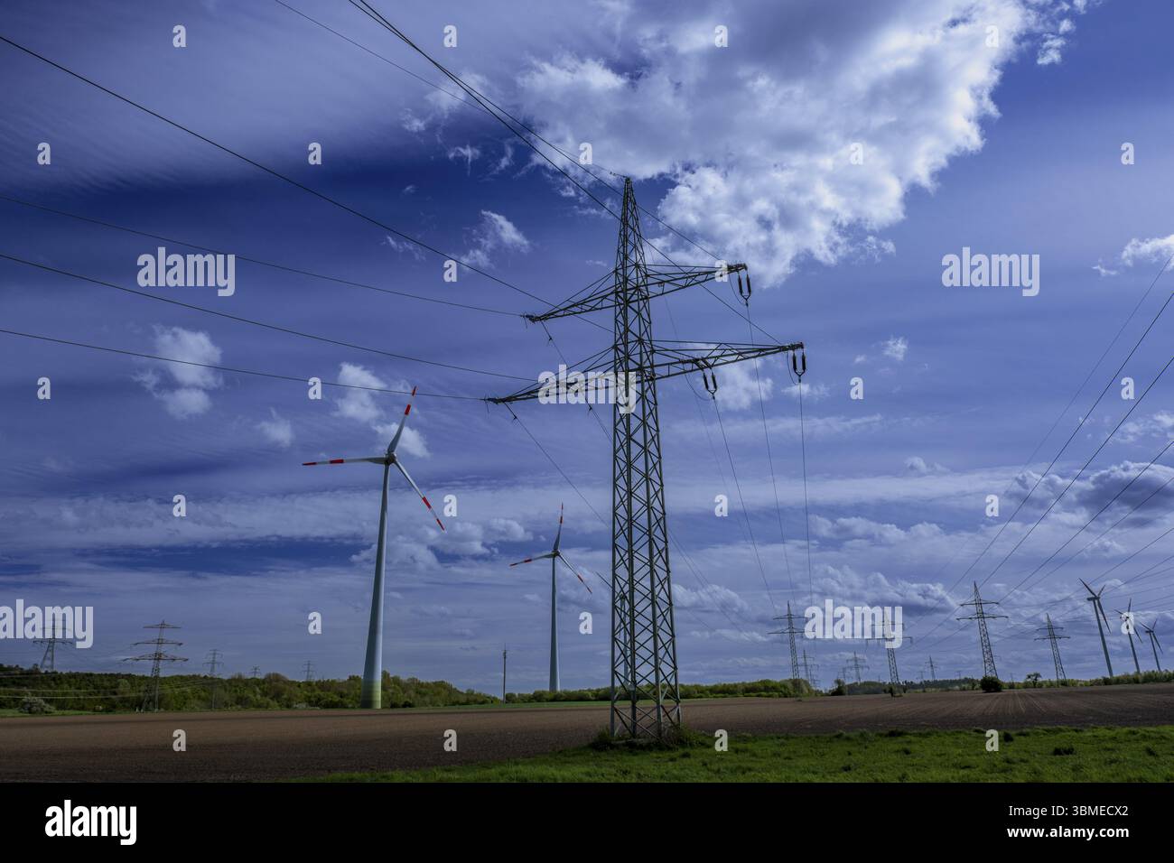Power pylons with high-voltage lines and wind turbines at the Avacon ...
